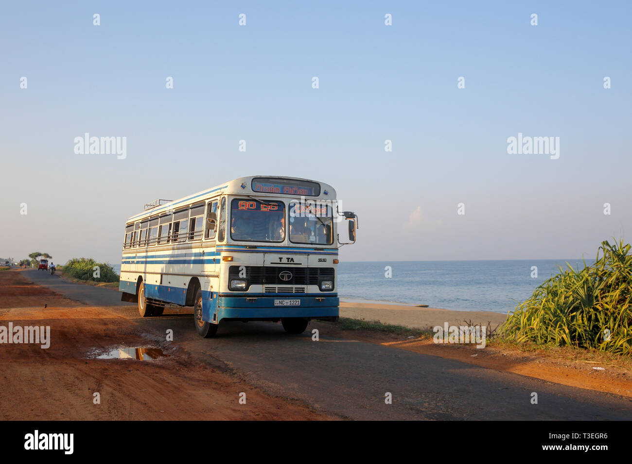 A passenger bus crossing the marine drive road at Chilaw in Srilanka ...