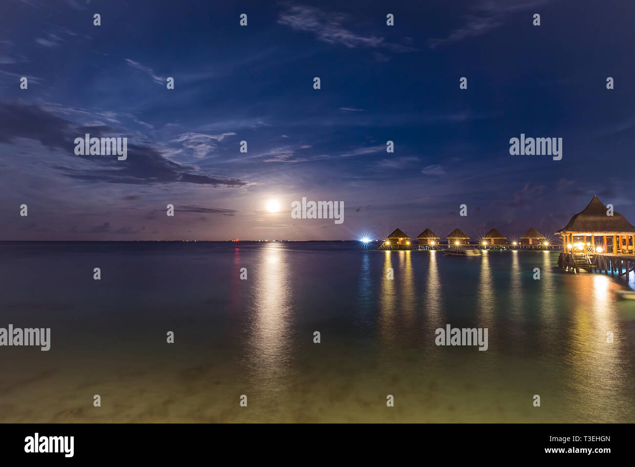 Maldives overwater huts moon rise scenery Stock Photo - Alamy