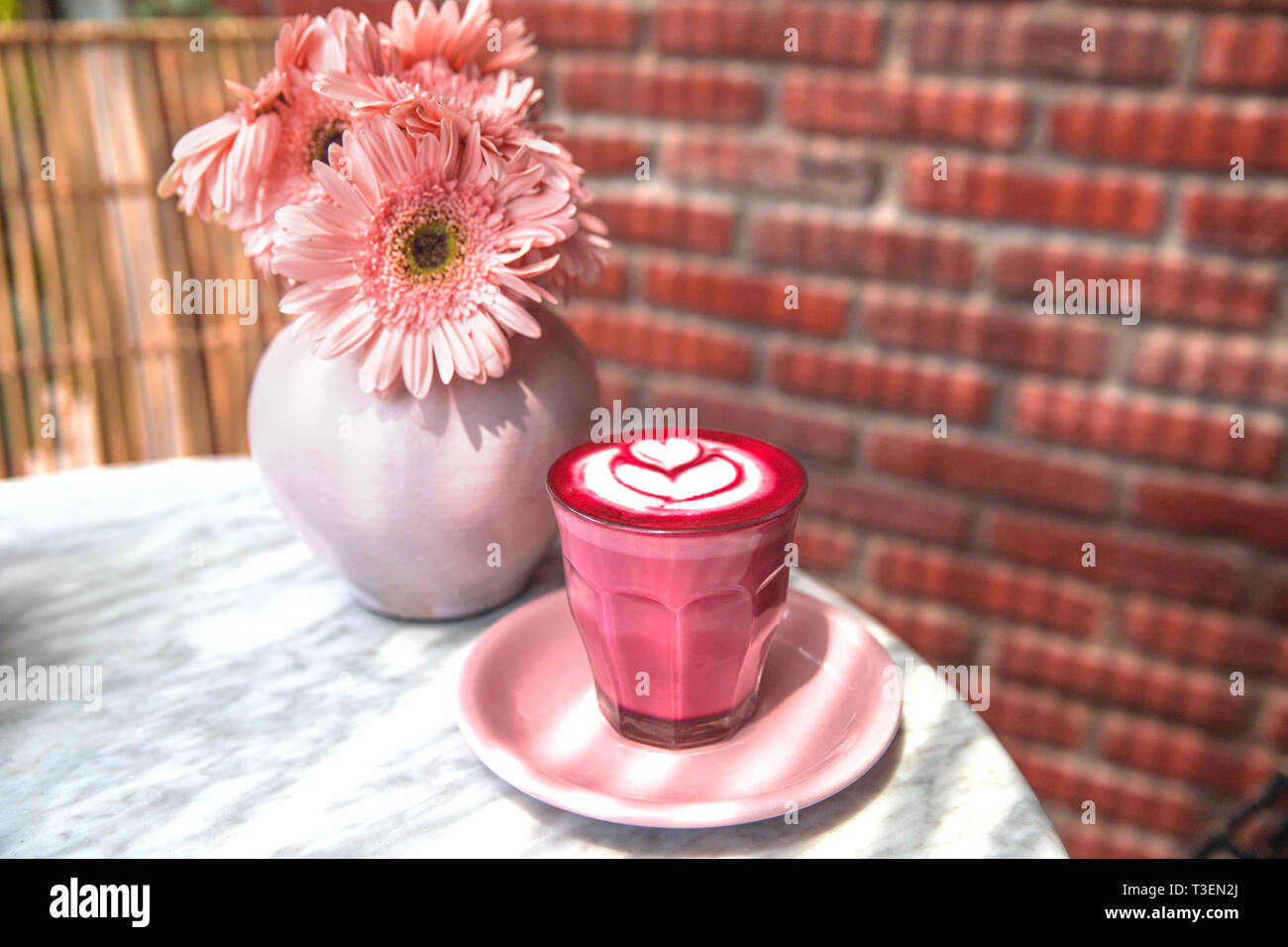 Pink Beetroot super latte on marble background closed to brick wall ...