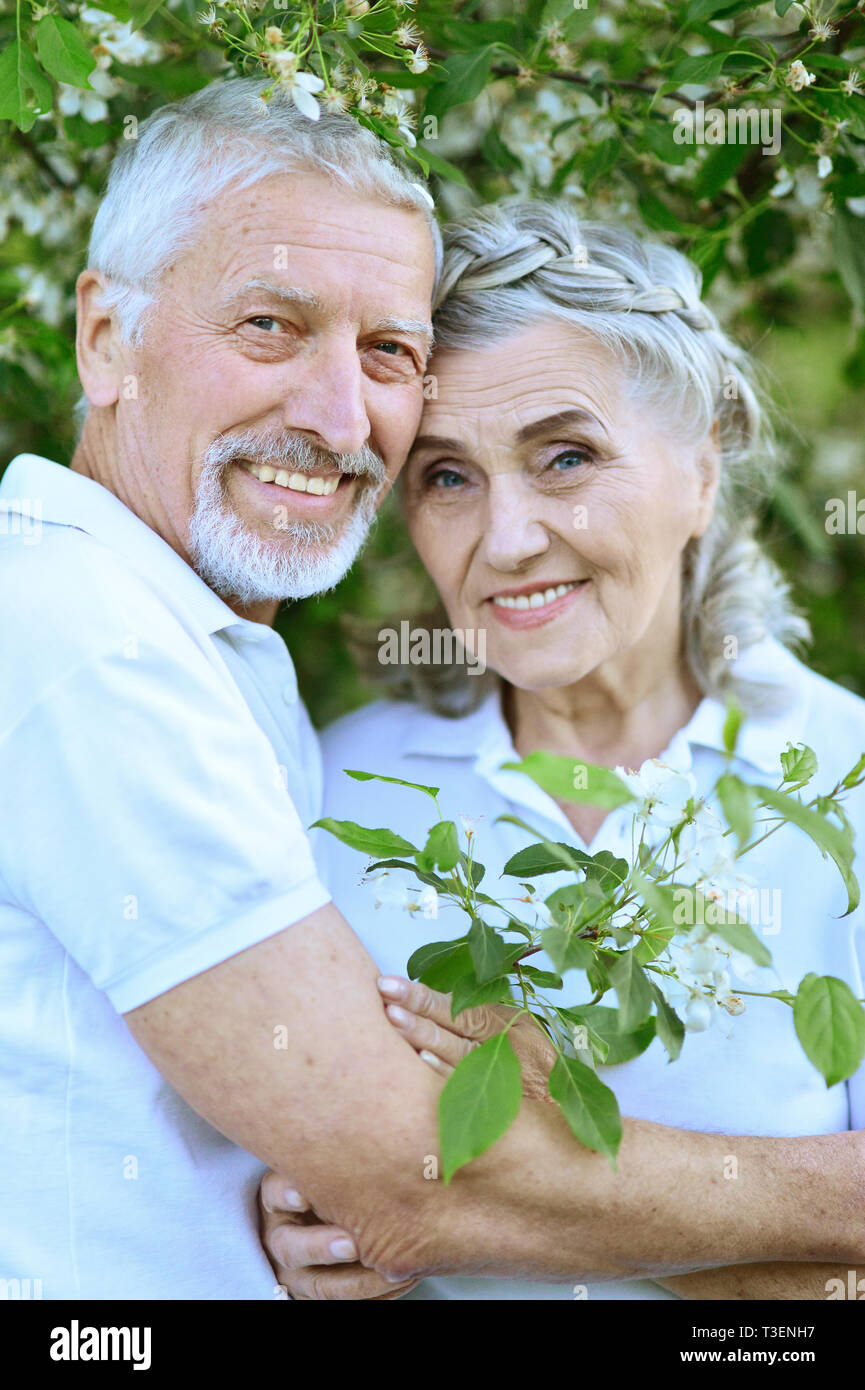 elder couple posing on flowers background Stock Photo - Alamy