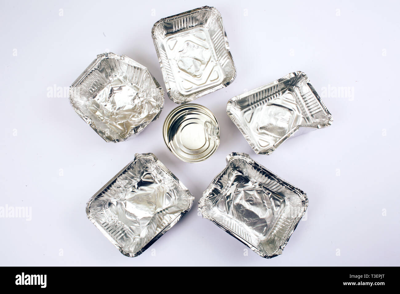 Plastic pollution concept. Metal can in the center of aluminum foil ...