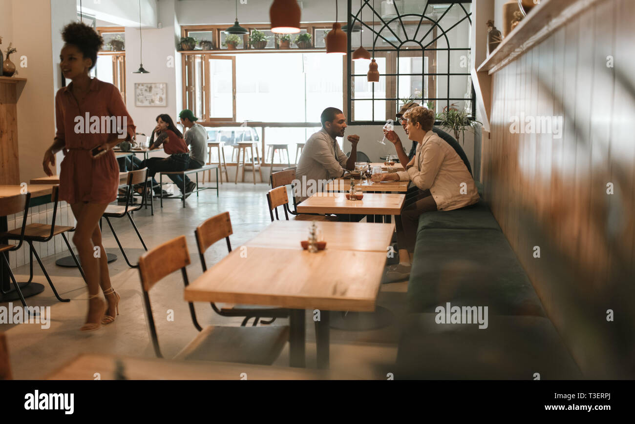 Friends talking together over drinks and lunch in a bistro Stock Photo ...