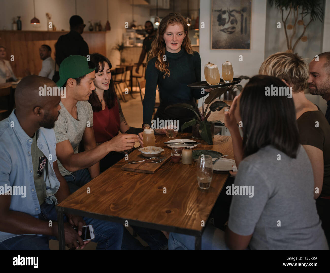 Waitress serving customers drinks in a bar at night Stock Photo - Alamy