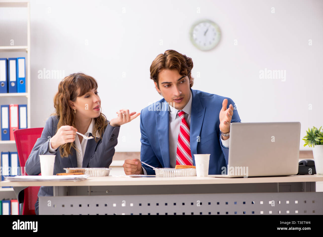 Two colleagues having lunch break at workplace Stock Photo - Alamy