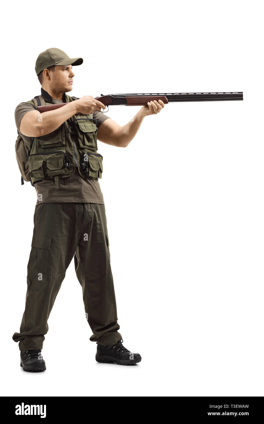 Full length shot of a hunter standing and aiming with a shotgun ...