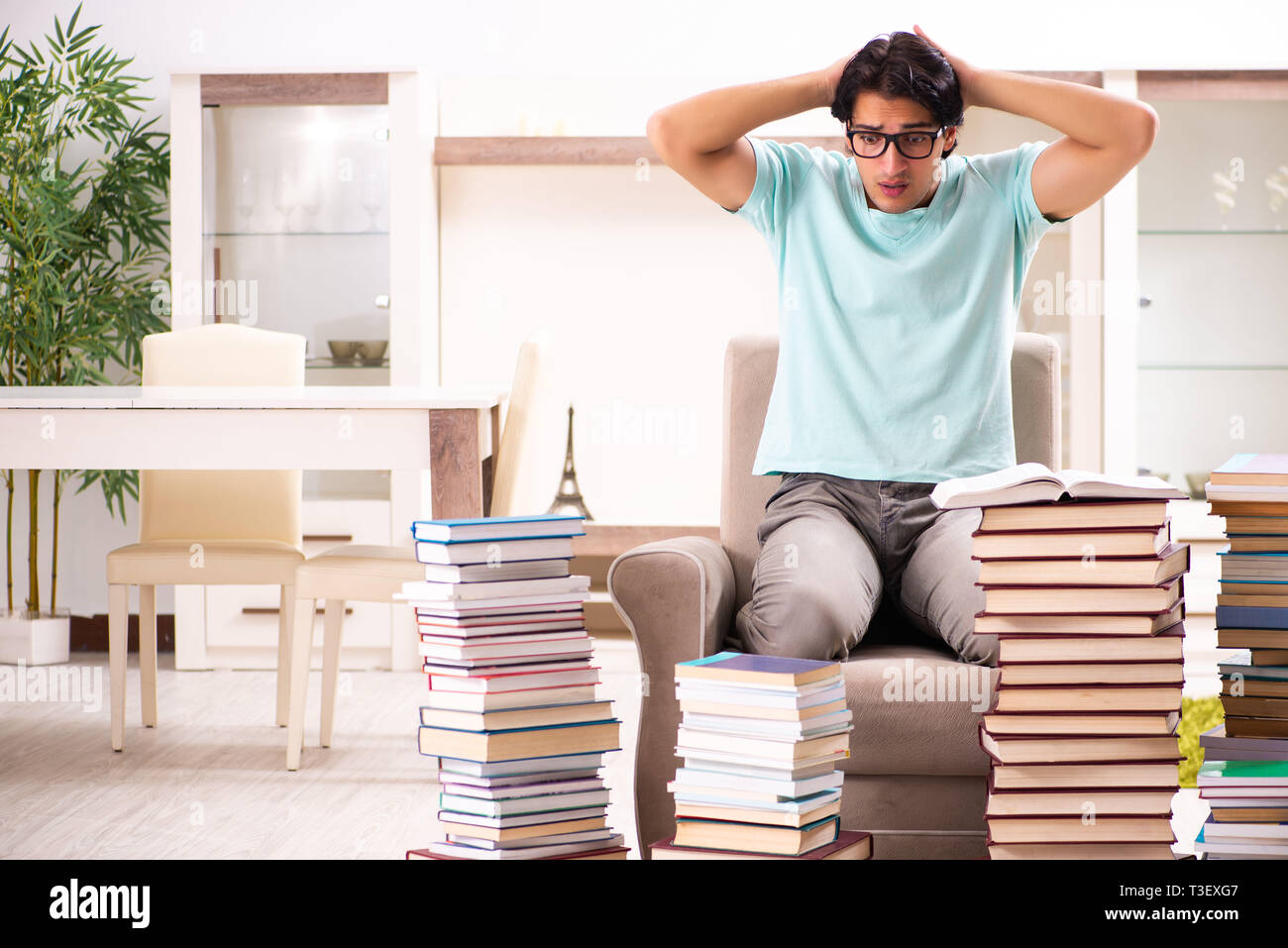 Male student with many books at home Stock Photo - Alamy