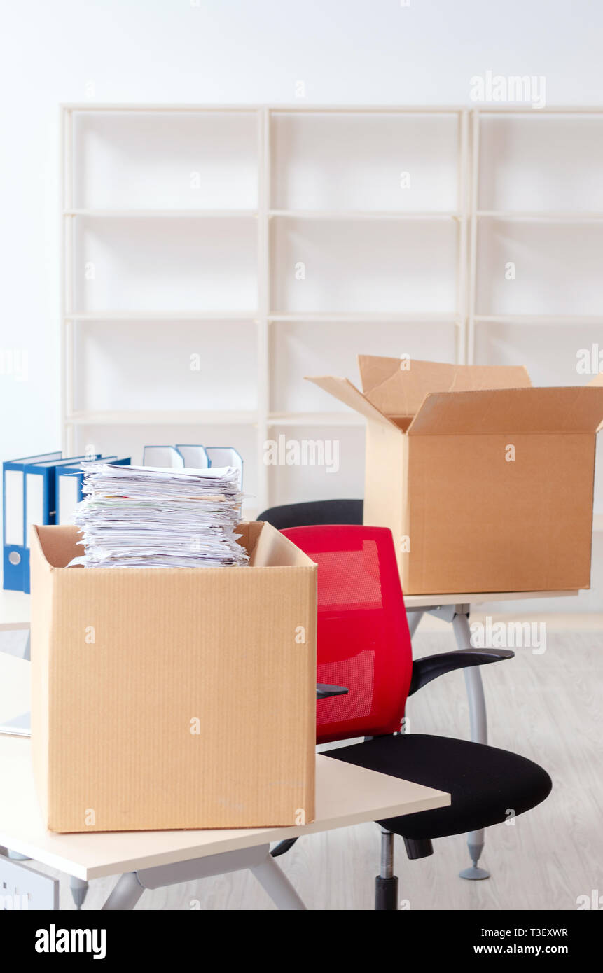Young man employee with boxes in the office Stock Photo - Alamy