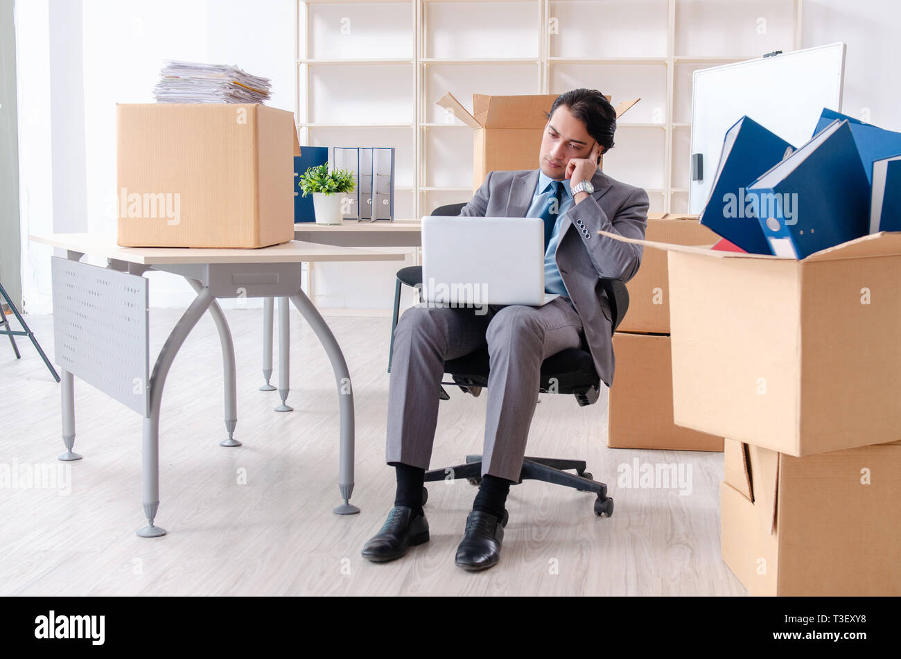 Young man employee with boxes in the office Stock Photo - Alamy