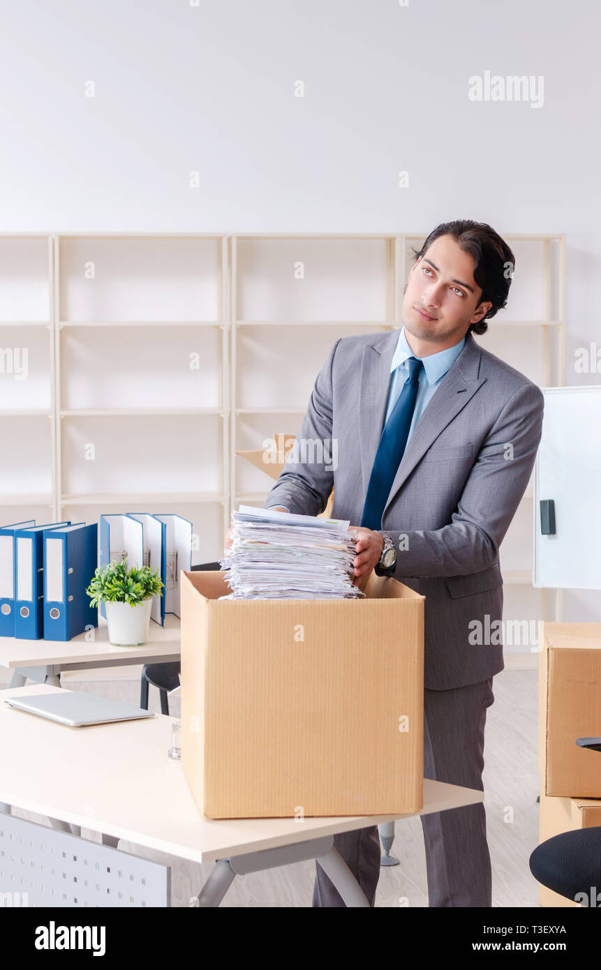 Young man employee with boxes in the office Stock Photo - Alamy