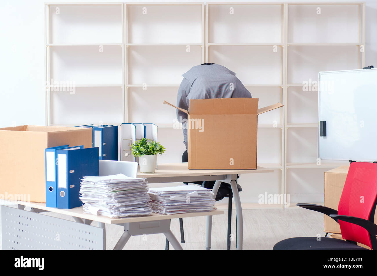 Young man employee with boxes in the office Stock Photo - Alamy