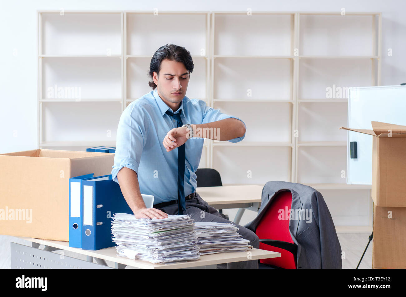 Young man employee with boxes in the office Stock Photo - Alamy