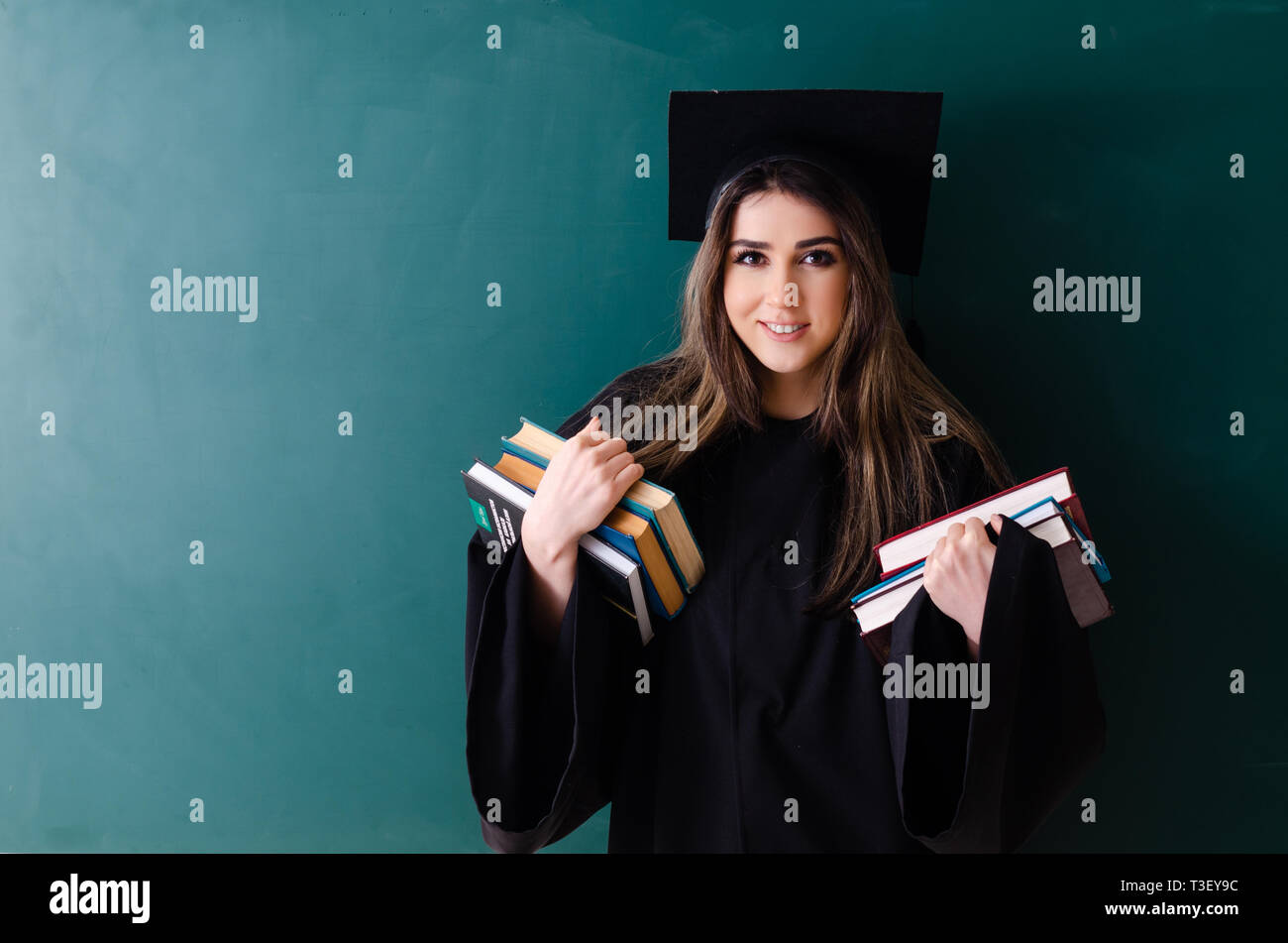 Female graduate student in front of green board Stock Photo - Alamy