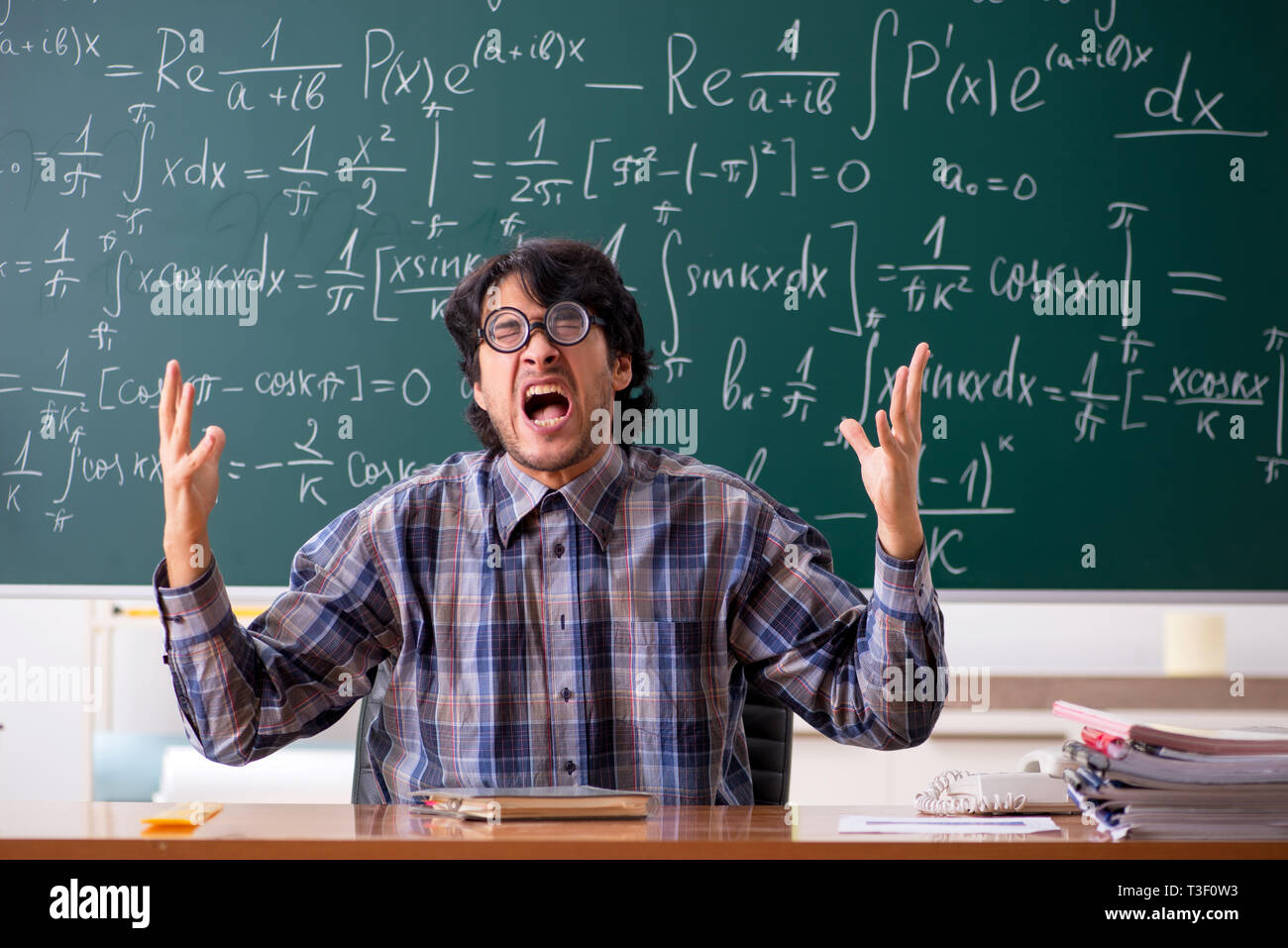 Funny male math teacher in the classroom Stock Photo - Alamy