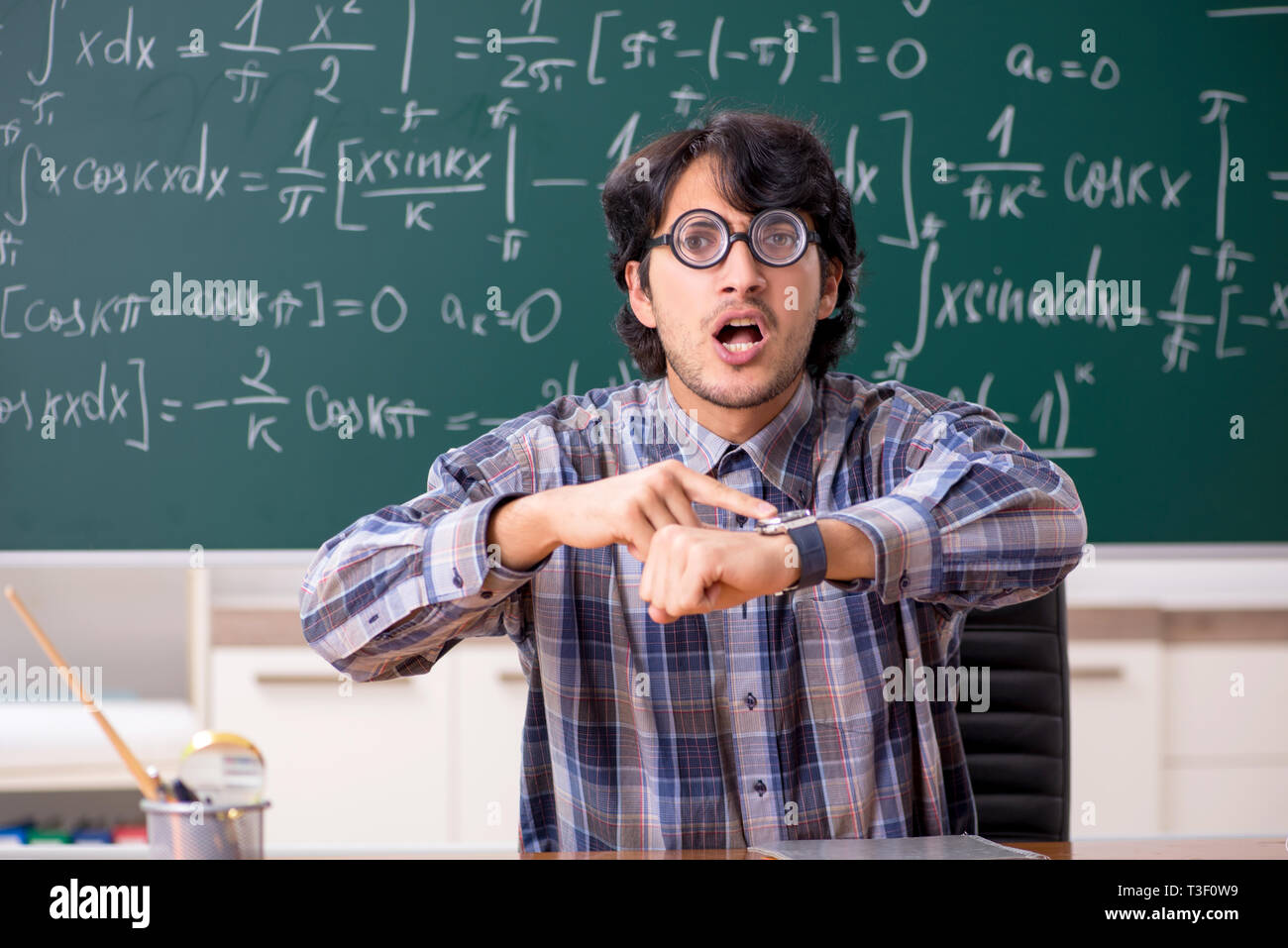 Funny male math teacher in the classroom Stock Photo - Alamy