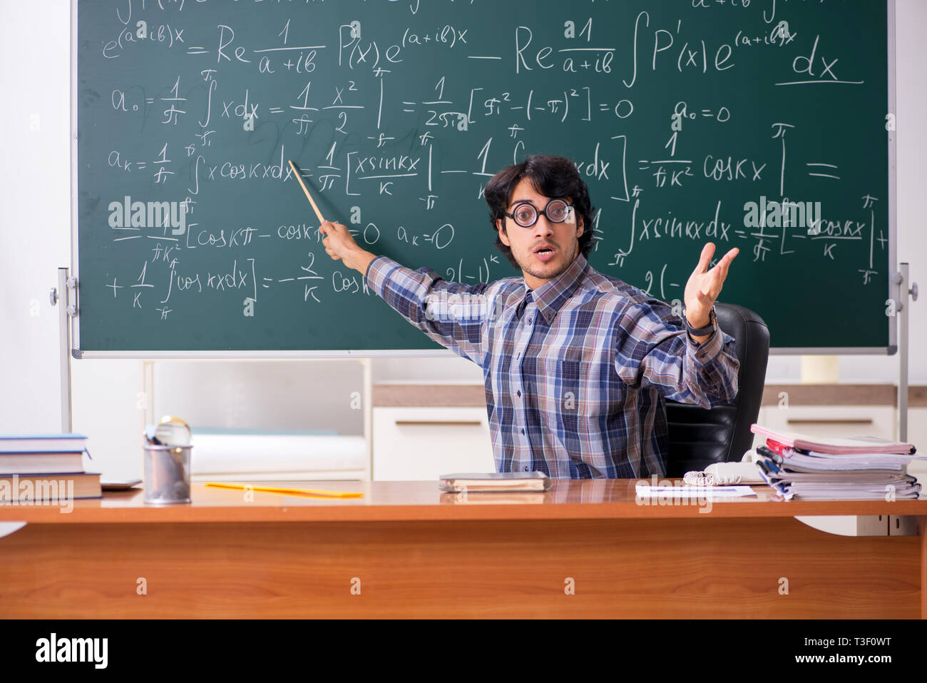 Funny male math teacher in the classroom Stock Photo - Alamy