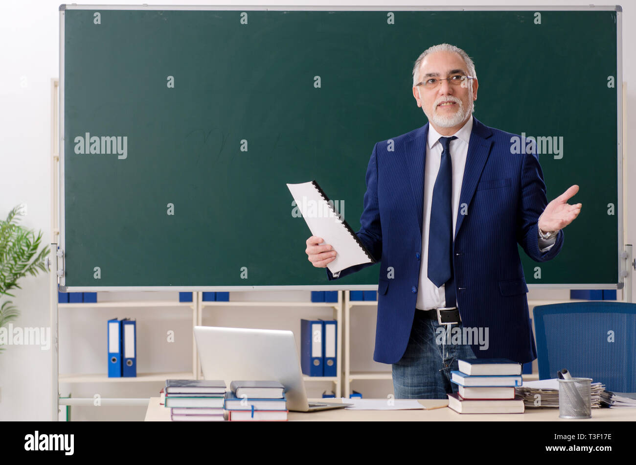 Aged male teacher in front of chalkboard Stock Photo - Alamy