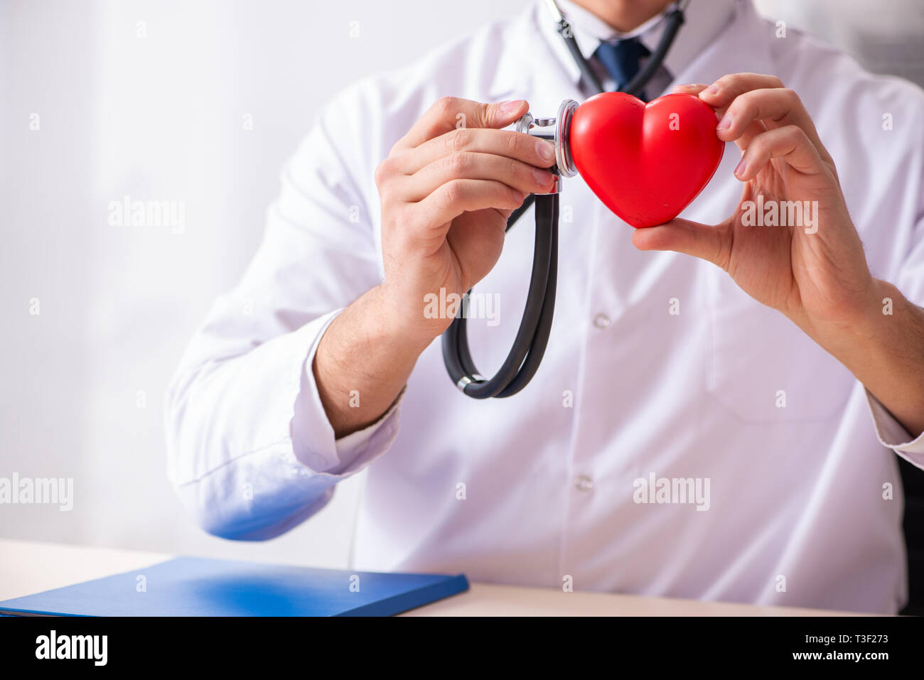 Male doctor cardiologist holding heart model Stock Photo - Alamy