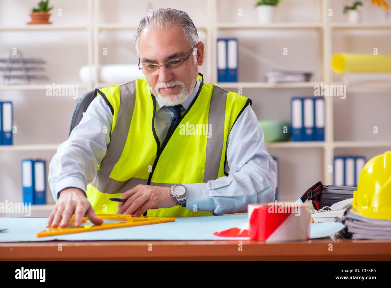Aged construction engineer working in the office Stock Photo - Alamy