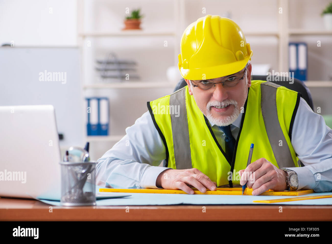 Aged construction engineer working in the office Stock Photo - Alamy