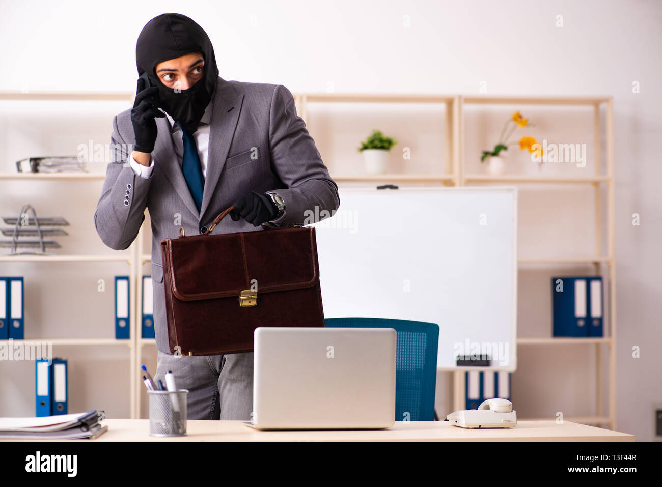 Male gangster stealing information from the office Stock Photo - Alamy