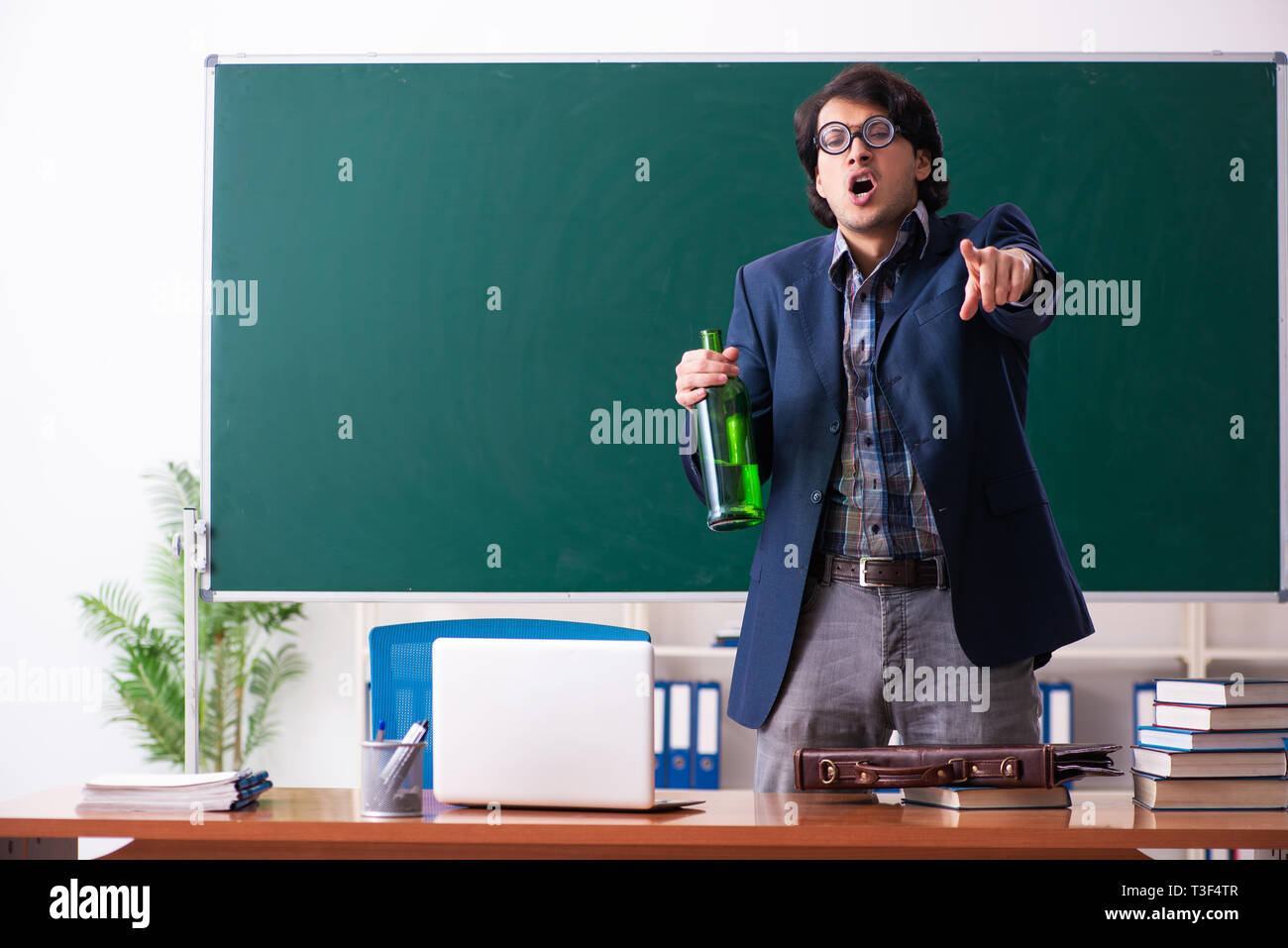 Male teacher drinking in the classroom Stock Photo - Alamy