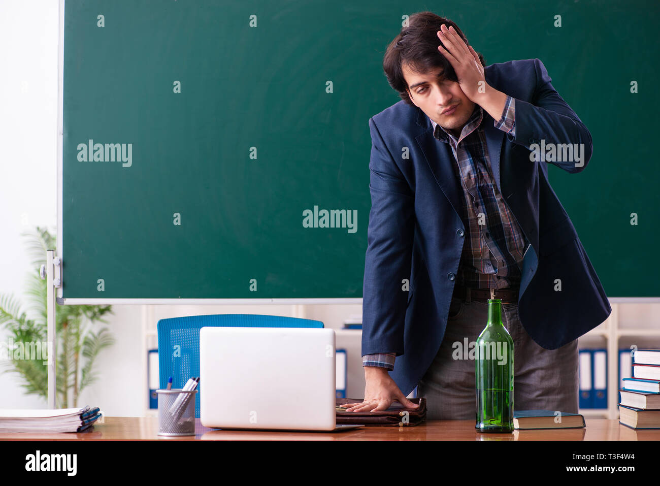 Male teacher drinking in the classroom Stock Photo - Alamy