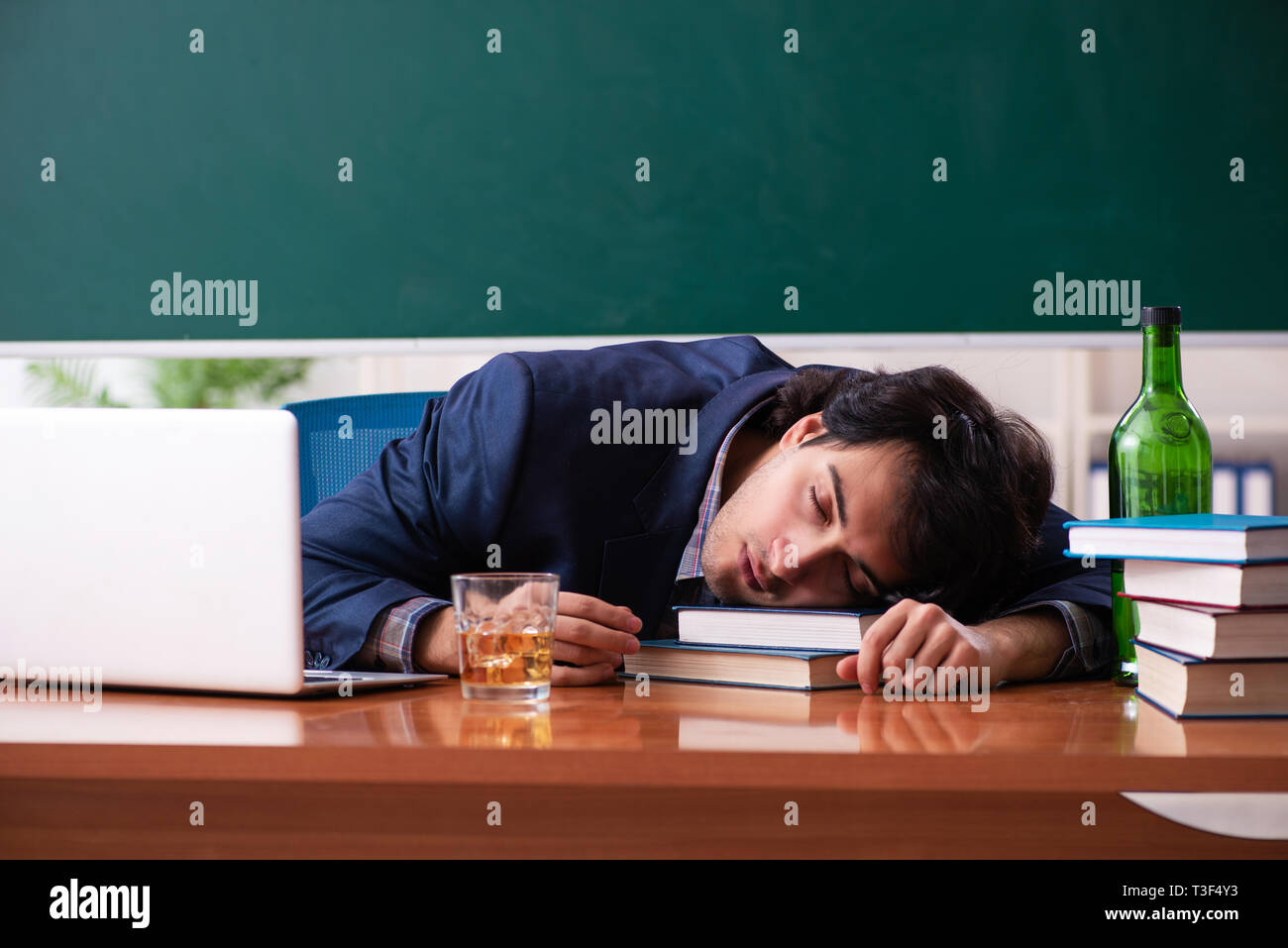 Male teacher drinking in the classroom Stock Photo - Alamy