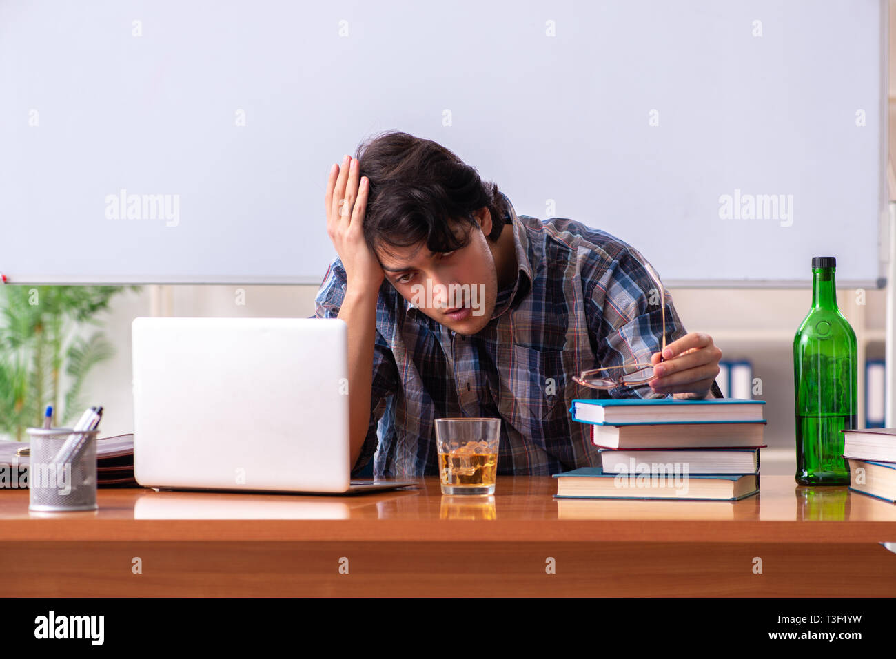 Male teacher drinking in the classroom Stock Photo - Alamy