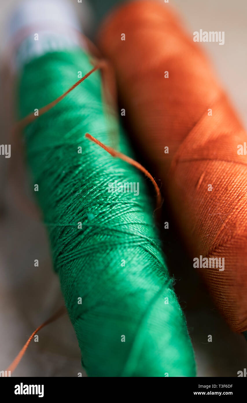 Orange and green thread used for sewing Stock Photo - Alamy