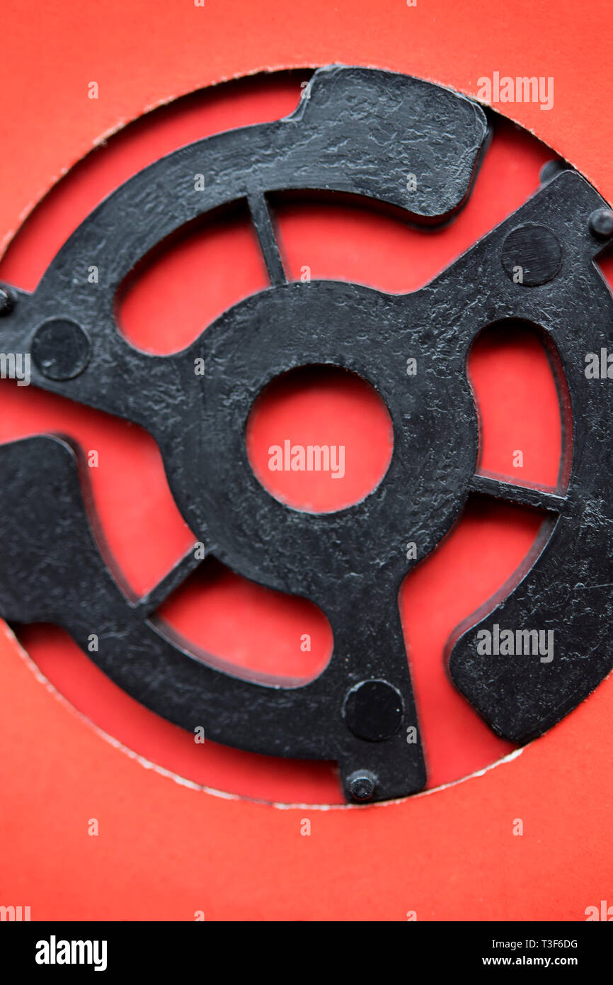 Detail of a plastic center adapter in the middle of a vinyl record ...
