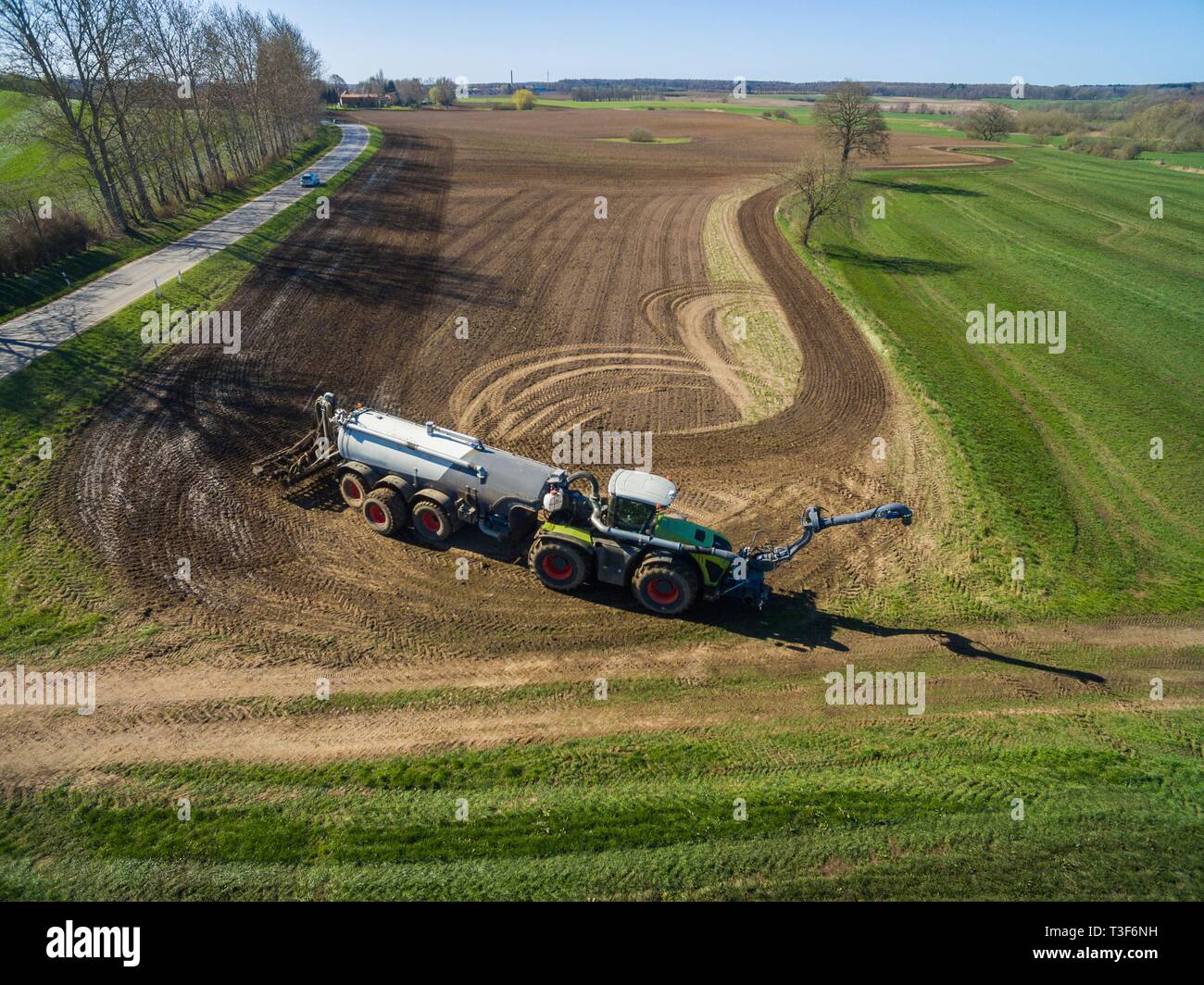 aerial view of a tractor with a modern fertilizer trailer and a second ...