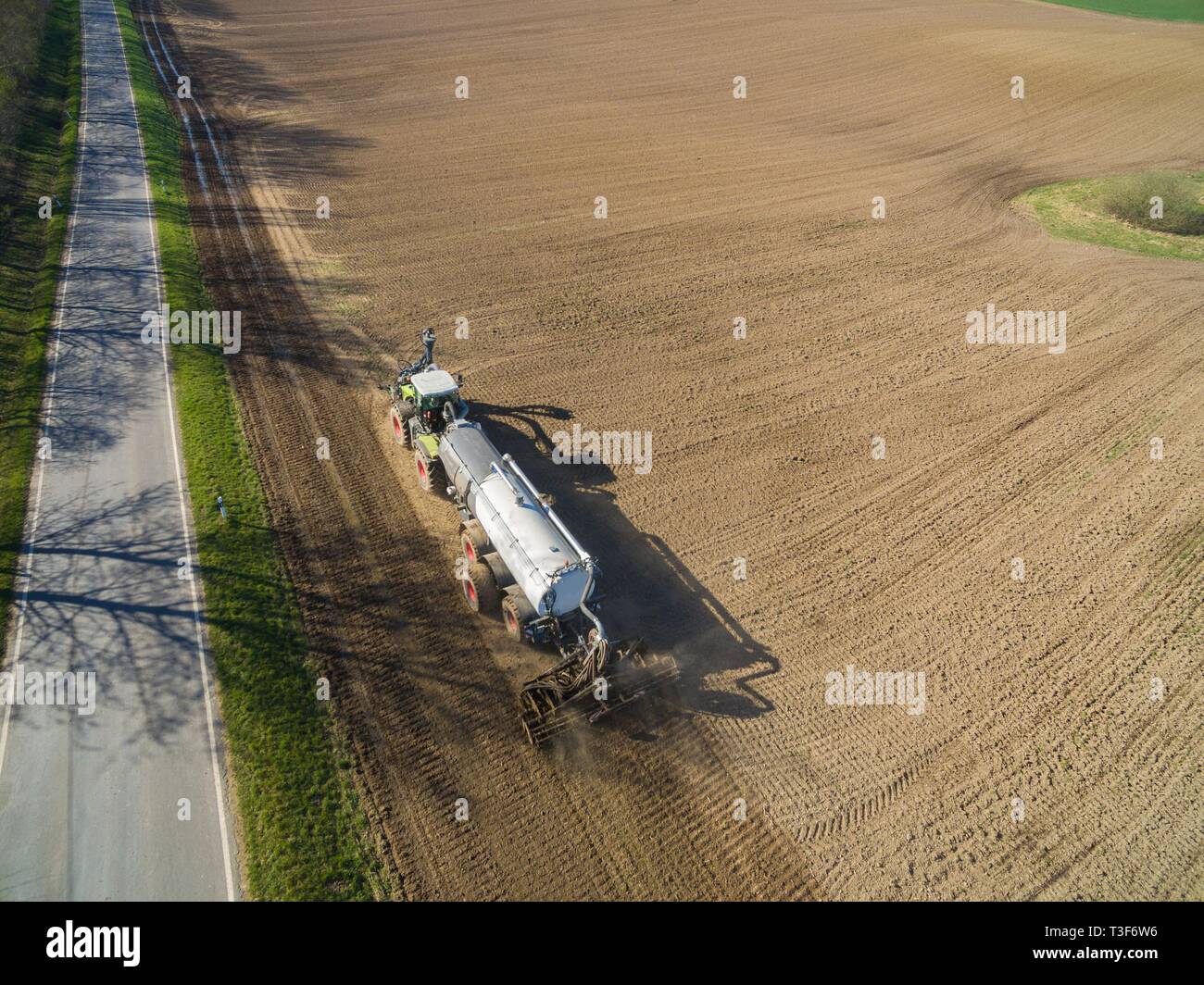 aerial view of a tractor with a modern fertilizer trailer and a second ...