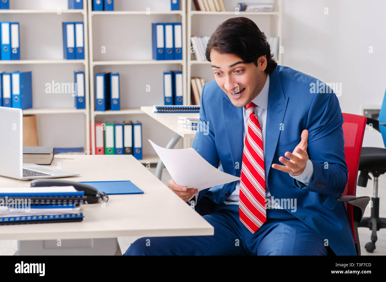 Young happy male employee in the office Stock Photo - Alamy