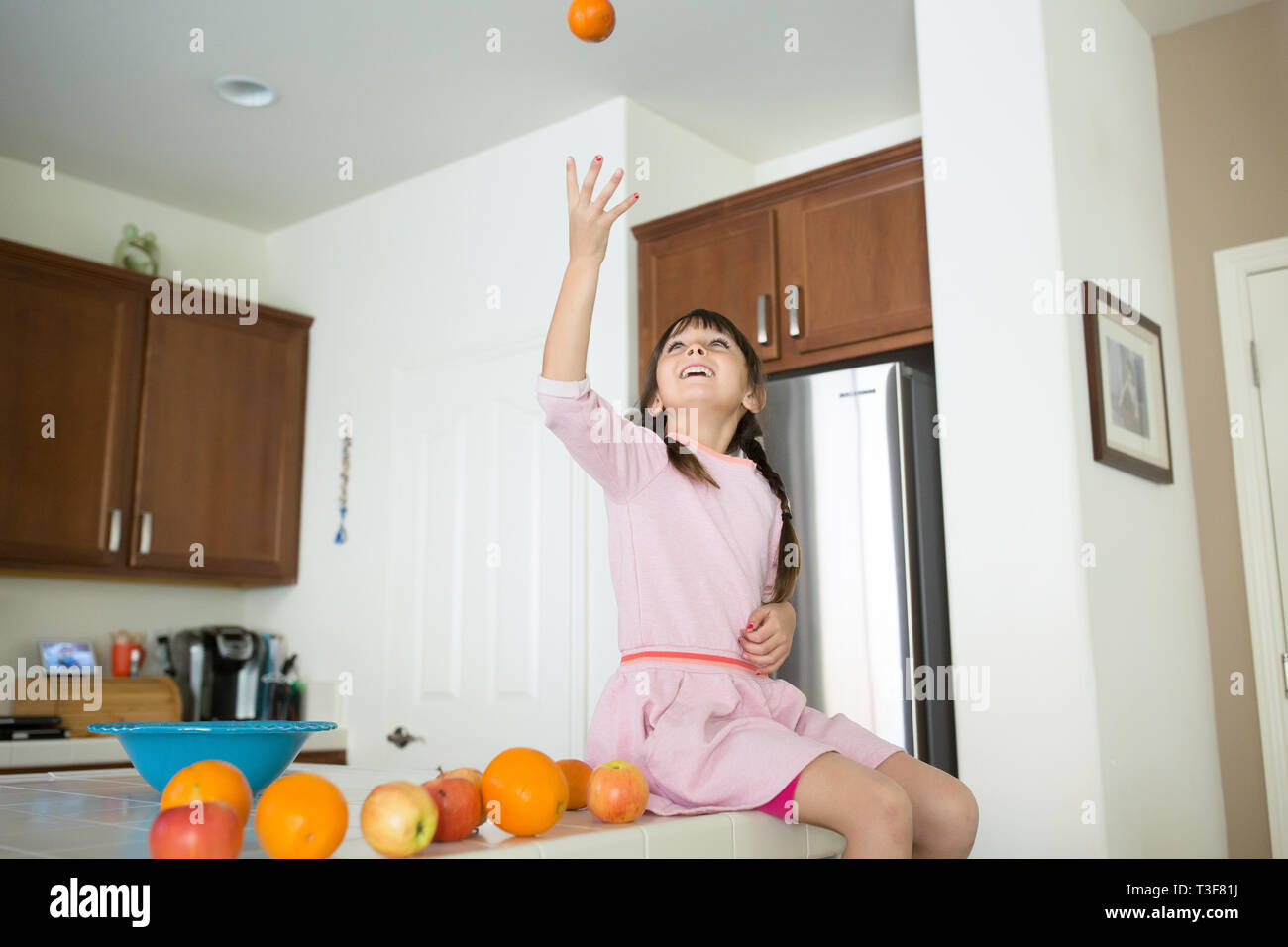 Girl is throwing oranges up in air and catching it Stock Photo - Alamy