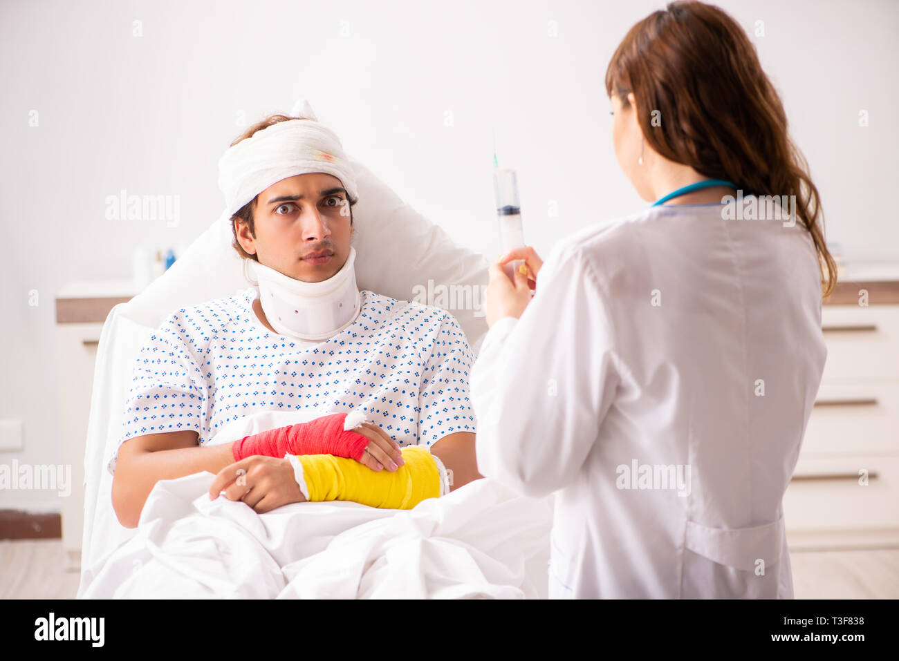 Young doctor examining injured patient Stock Photo - Alamy