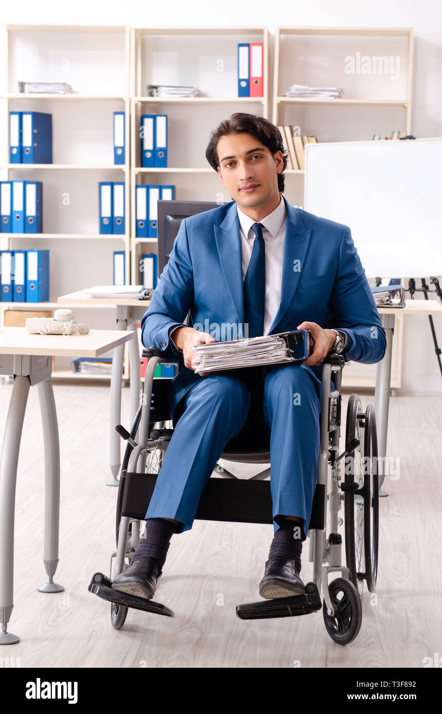 Male employee in wheelchair working at the office Stock Photo - Alamy