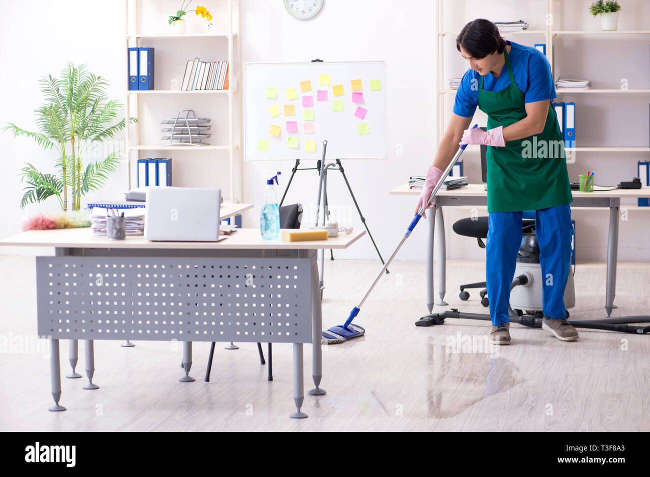 Male handsome professional cleaner working in the office Stock Photo ...