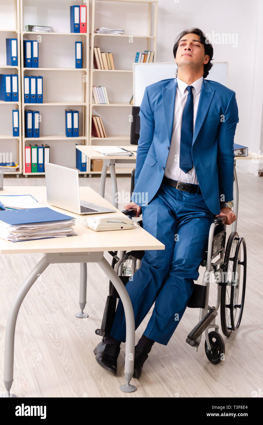 Male employee in wheelchair working at the office Stock Photo - Alamy