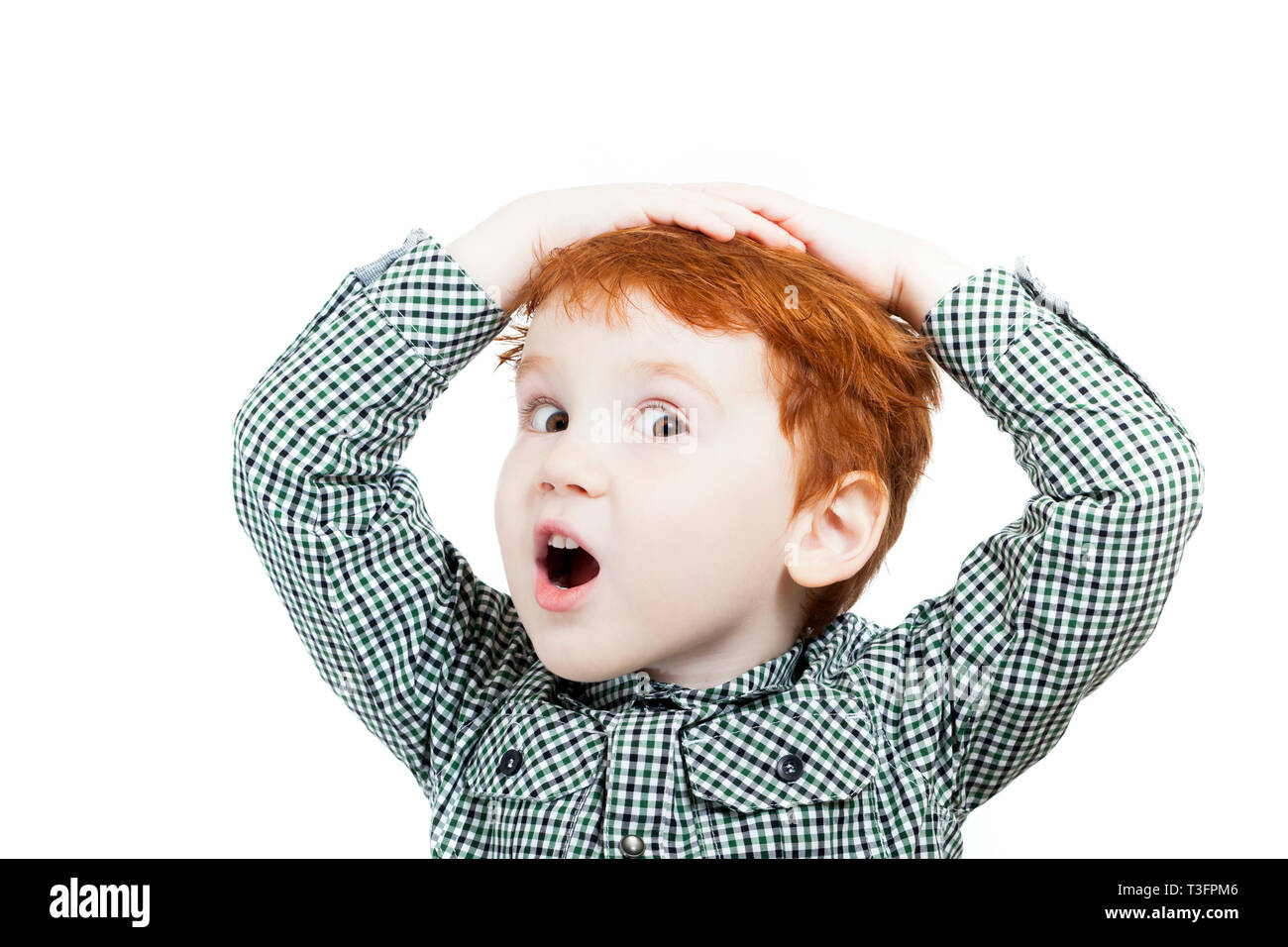 The complained boy is holding onto his head against a light background ...