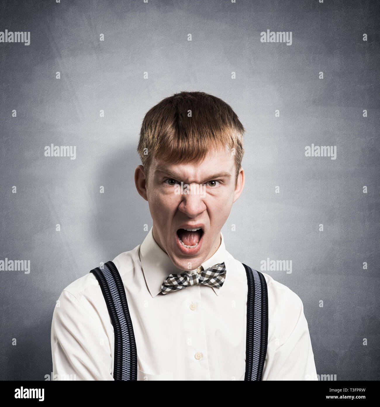 Frenzied teenager screaming with anger. Emotional redhead boy has ...