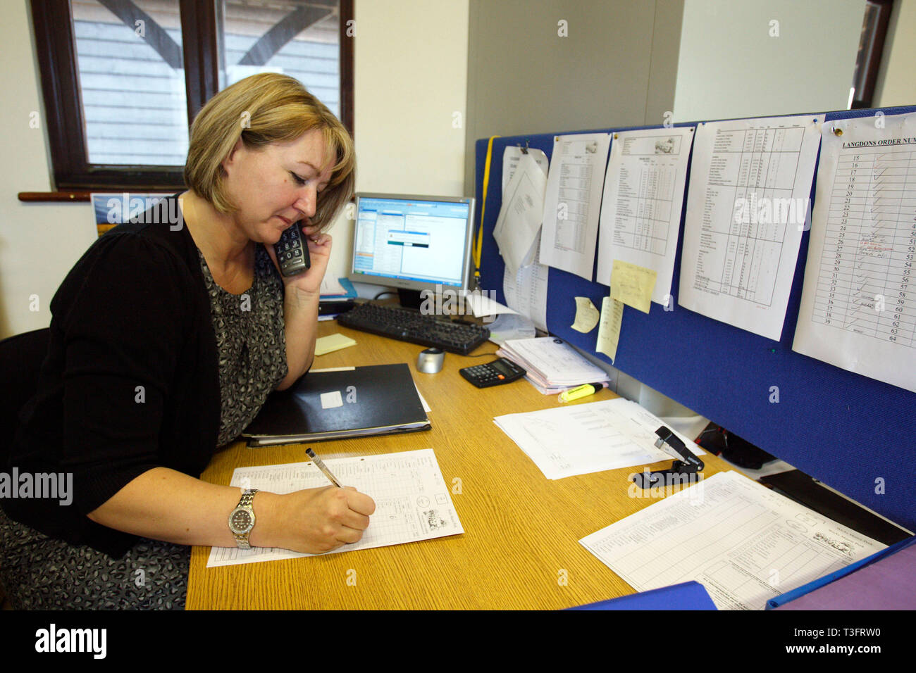 Officer worker taking food orders at Wicks Manor pig farm, supplying ...