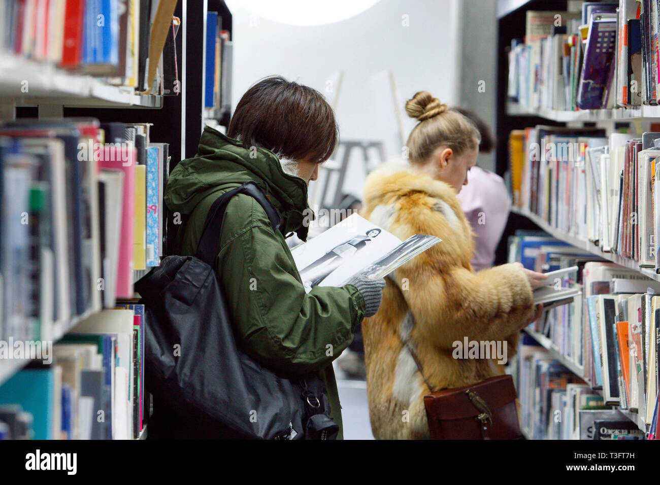 Student looking through books in the Study Zone and library ...