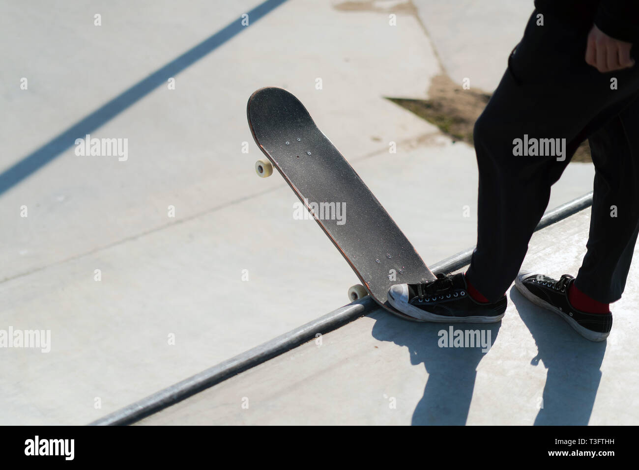 Young skateboard athlete standing on the ramp preparing to drop in on a ...