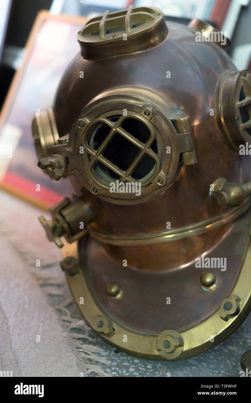 Old antique metal scuba helmet on the ground. Historic copper aqualung ...