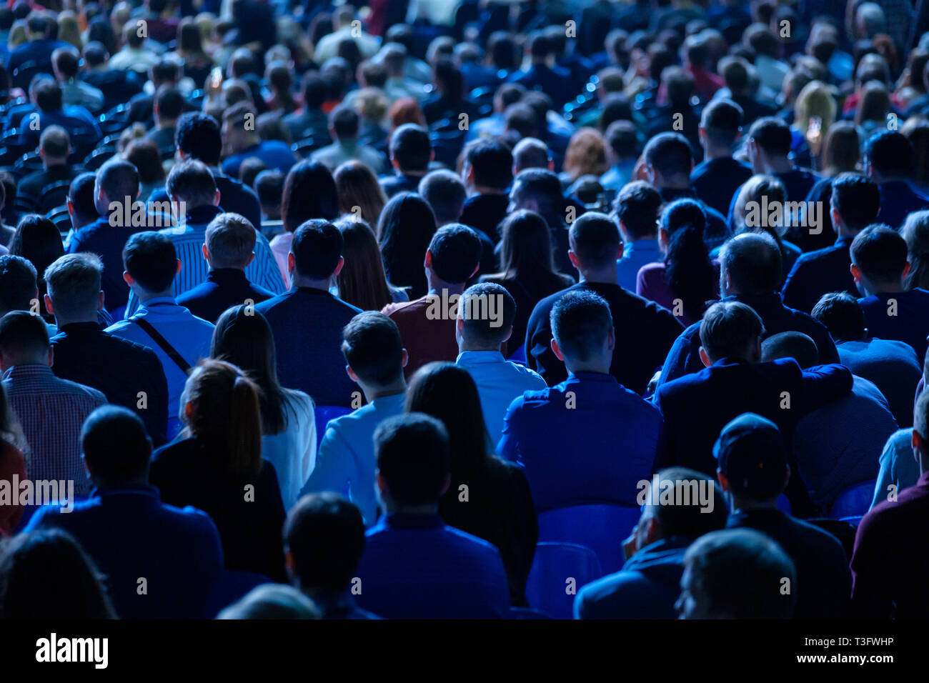 Audience listens to the lecturer at the business conference, back view ...