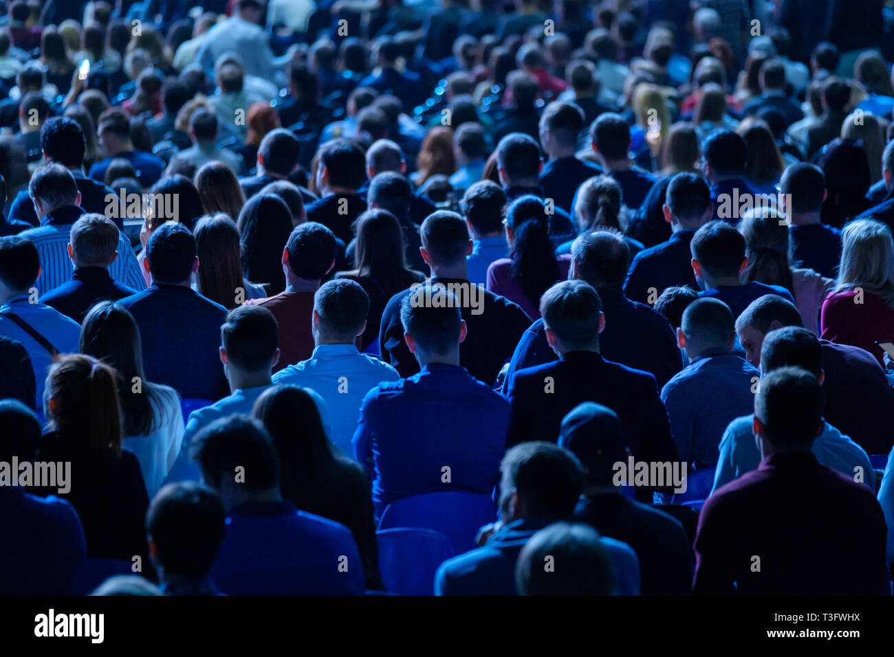 Audience listens to the lecturer at the business conference, back view ...