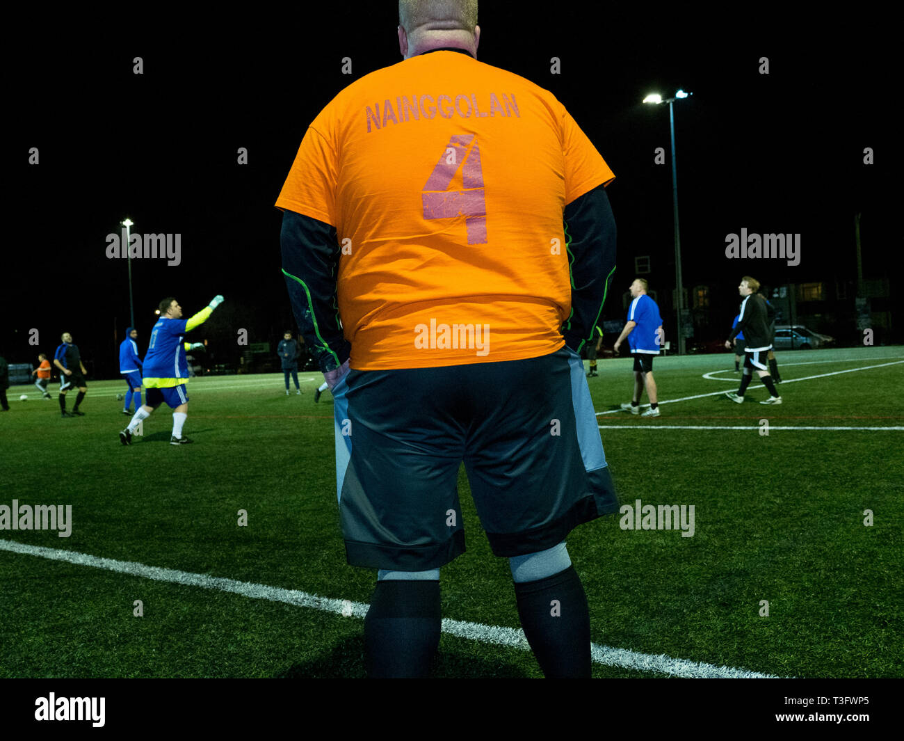An overweigh man watches a Man v Fat football match. The league is ...