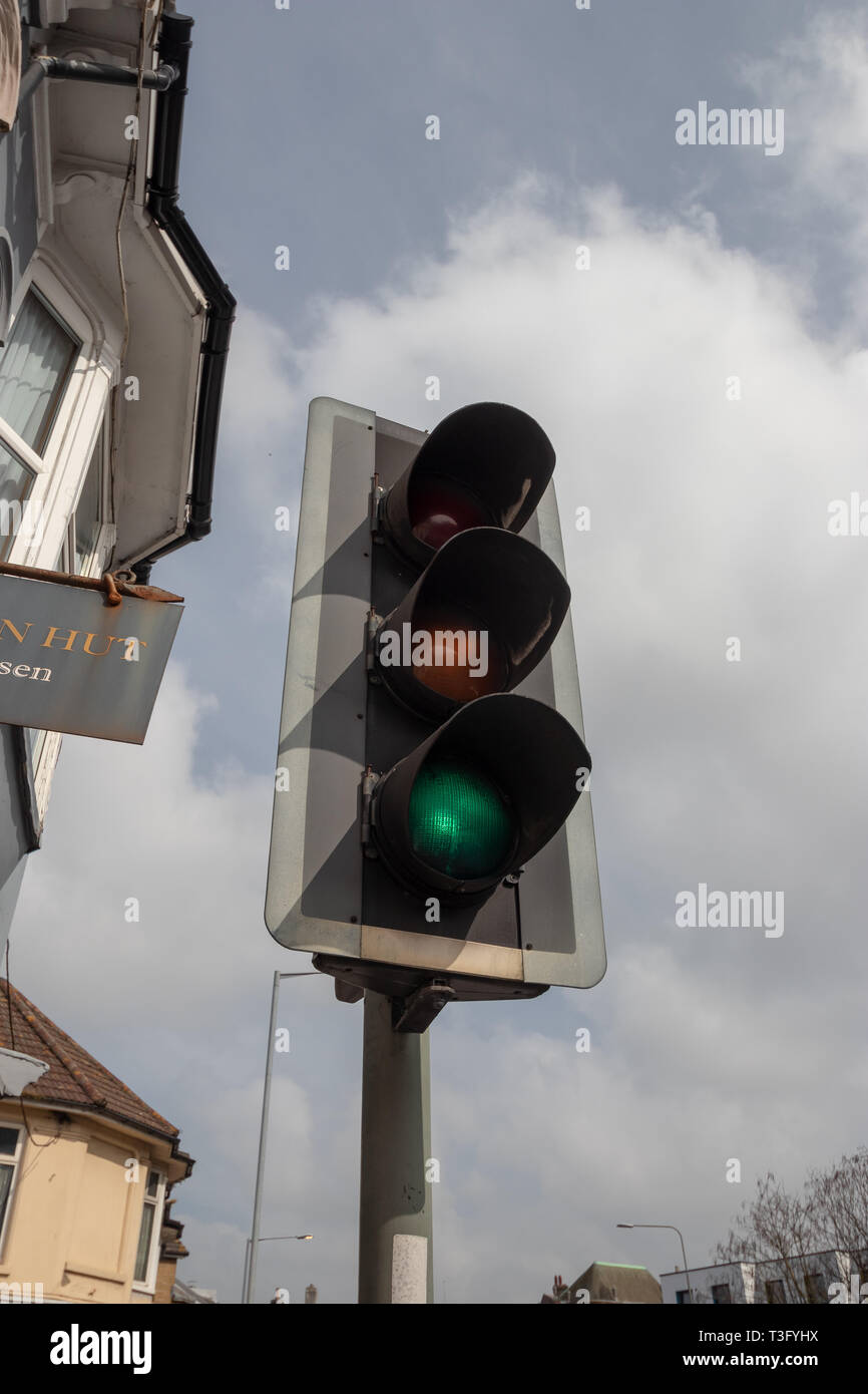 British traffic lights during the day with blue sky and clouds behind ...