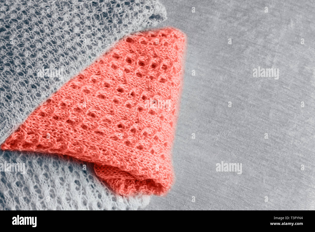 Pile of stylish knitted pastel colored sweaters and one in color of the ...