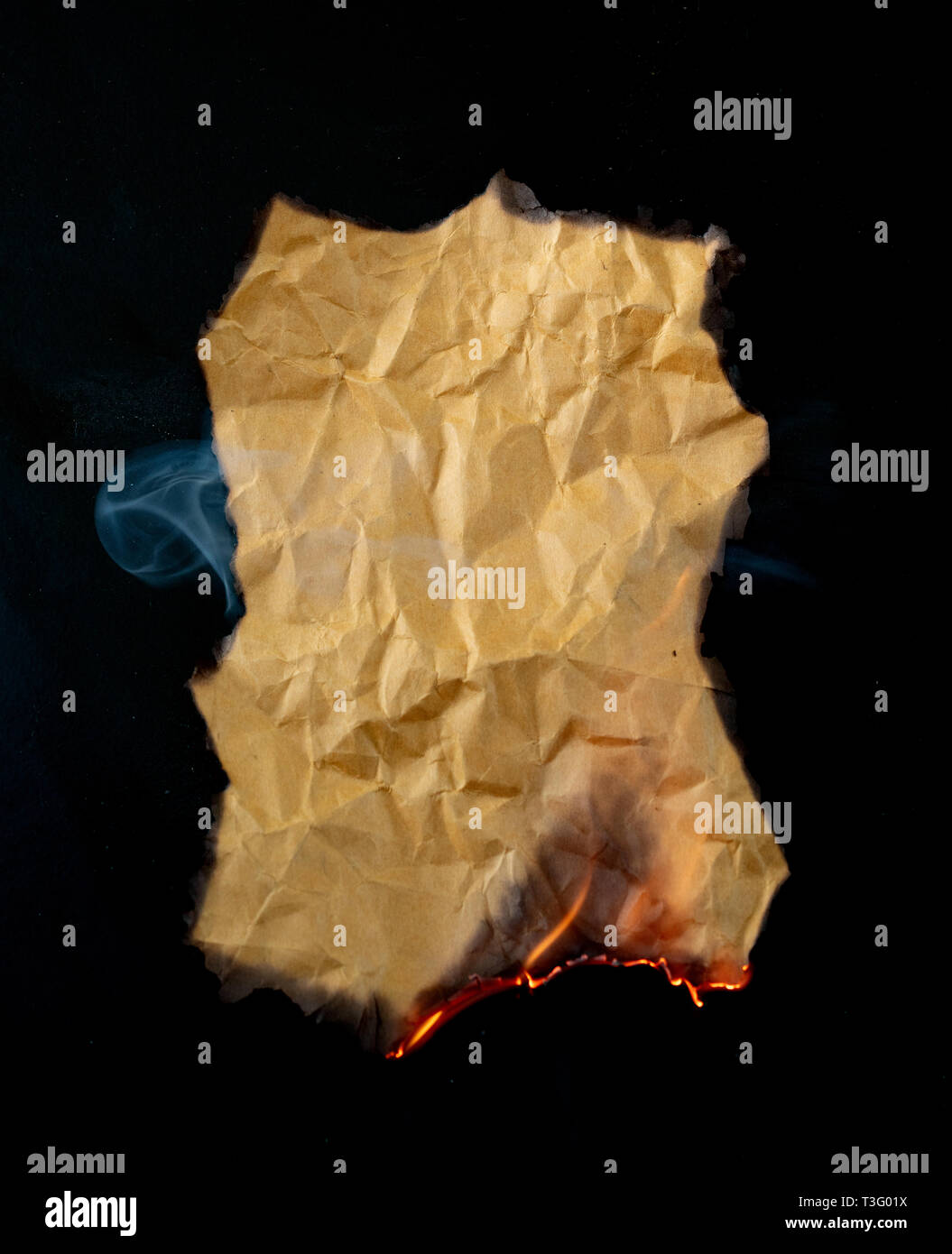 burning piece of crumpled paper on black background Stock Photo - Alamy